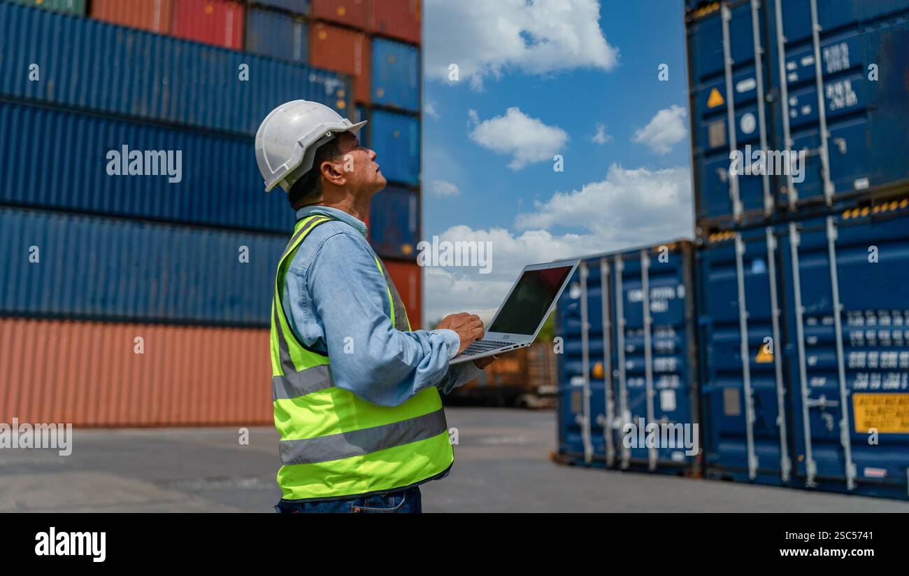 Engineer or foreman wears PPE checking container storage with cargo ...