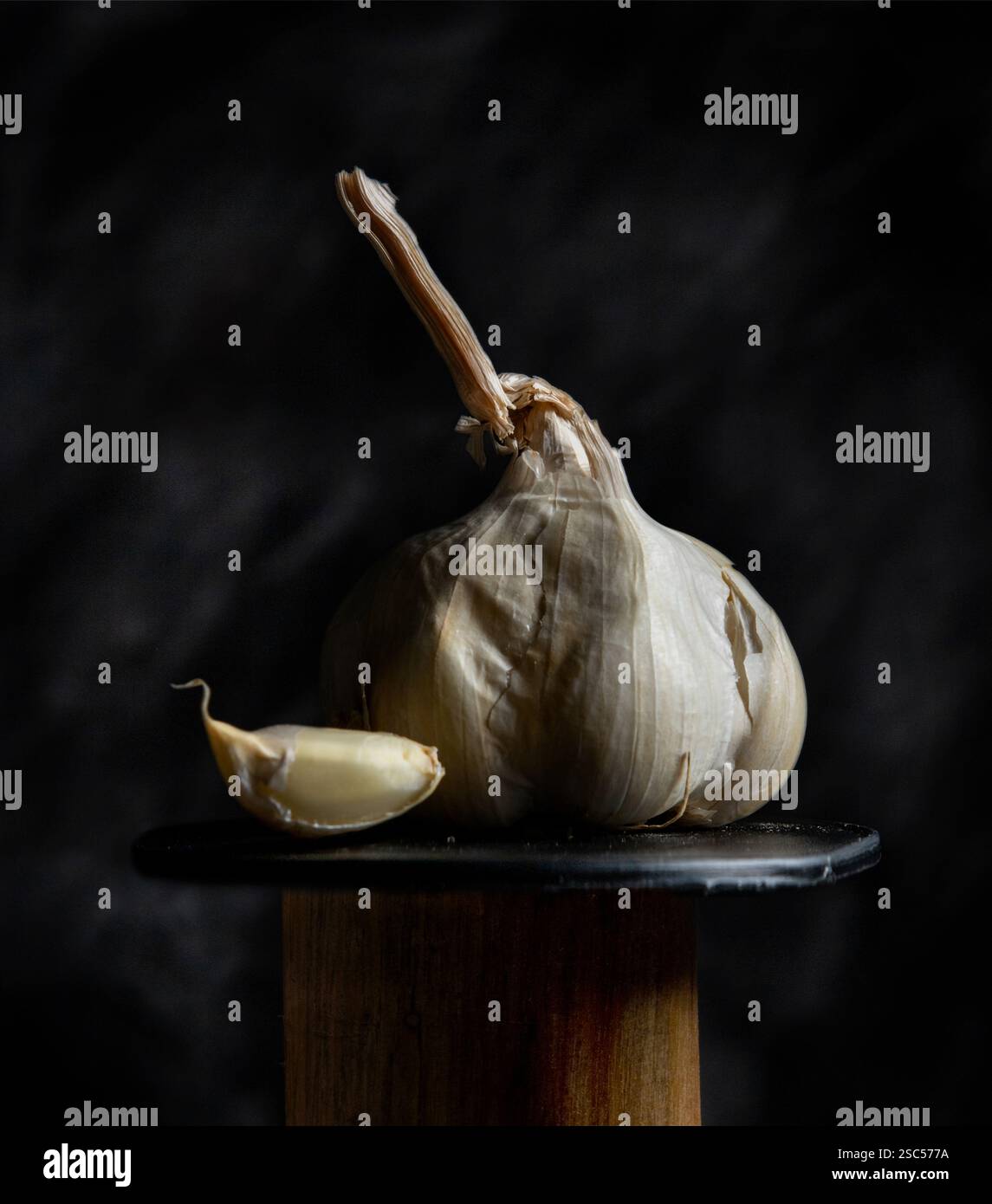 A clove of garlic and a whole garlic clove on a wooden base Stock Photo ...