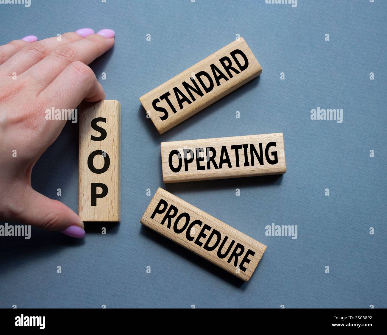 SOP - Standard Operating Procedure symbol. Wooden blocks with word SLA ...
