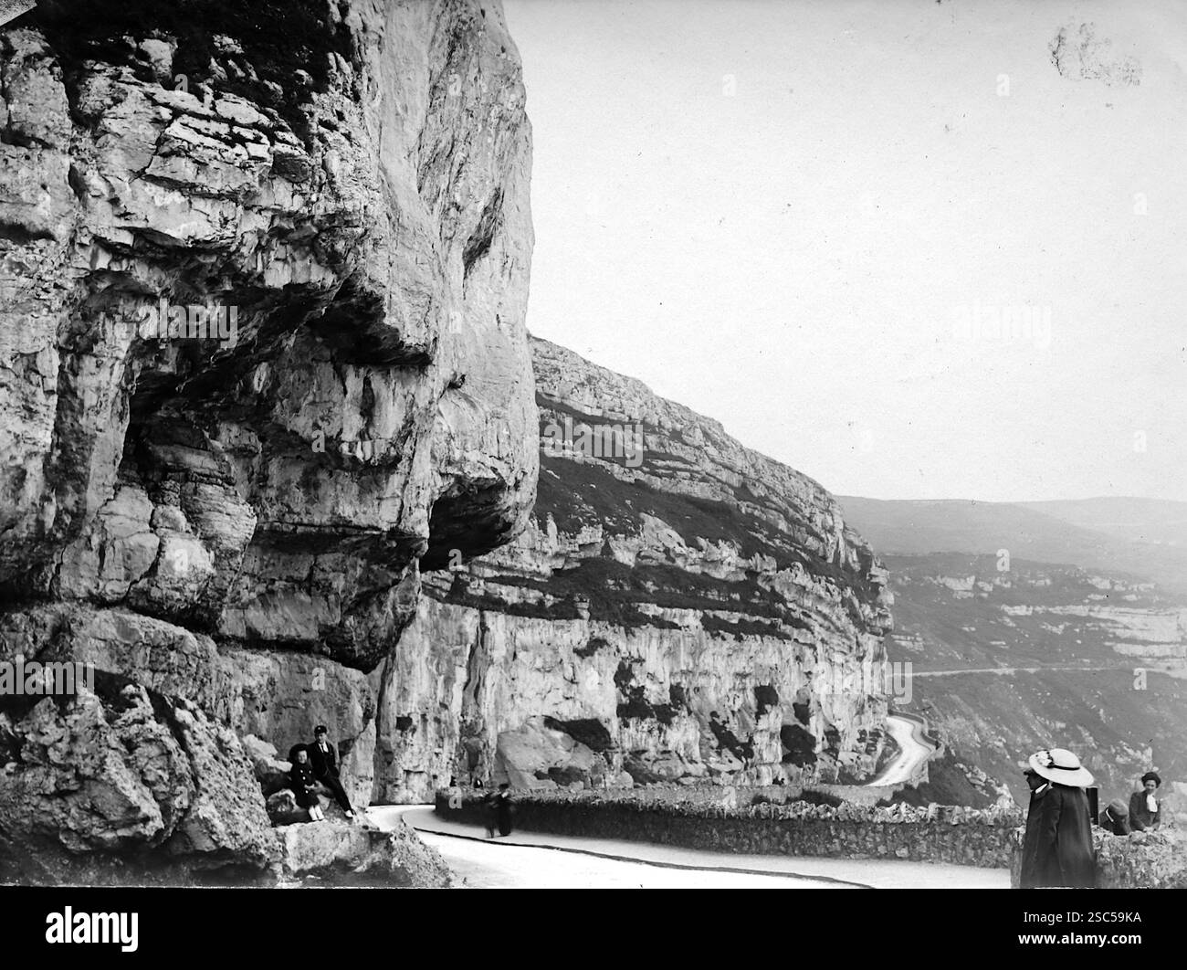 People and the rocky cliff face on Marine Drive in Llandudno, a ...