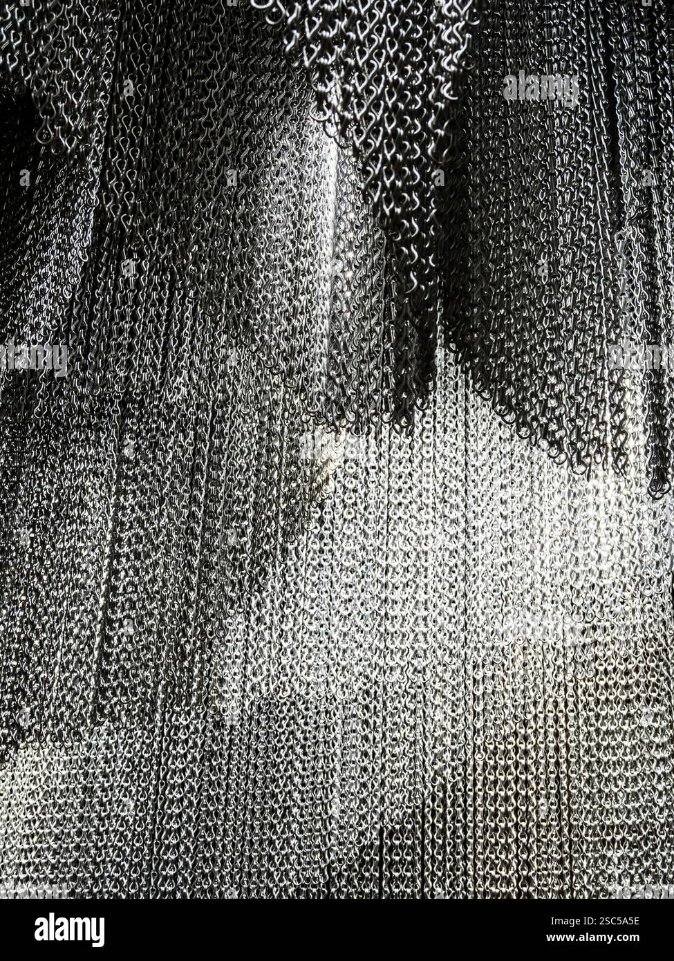Cose-up of the cascading aluminum chain curtains in the stairwell of ...