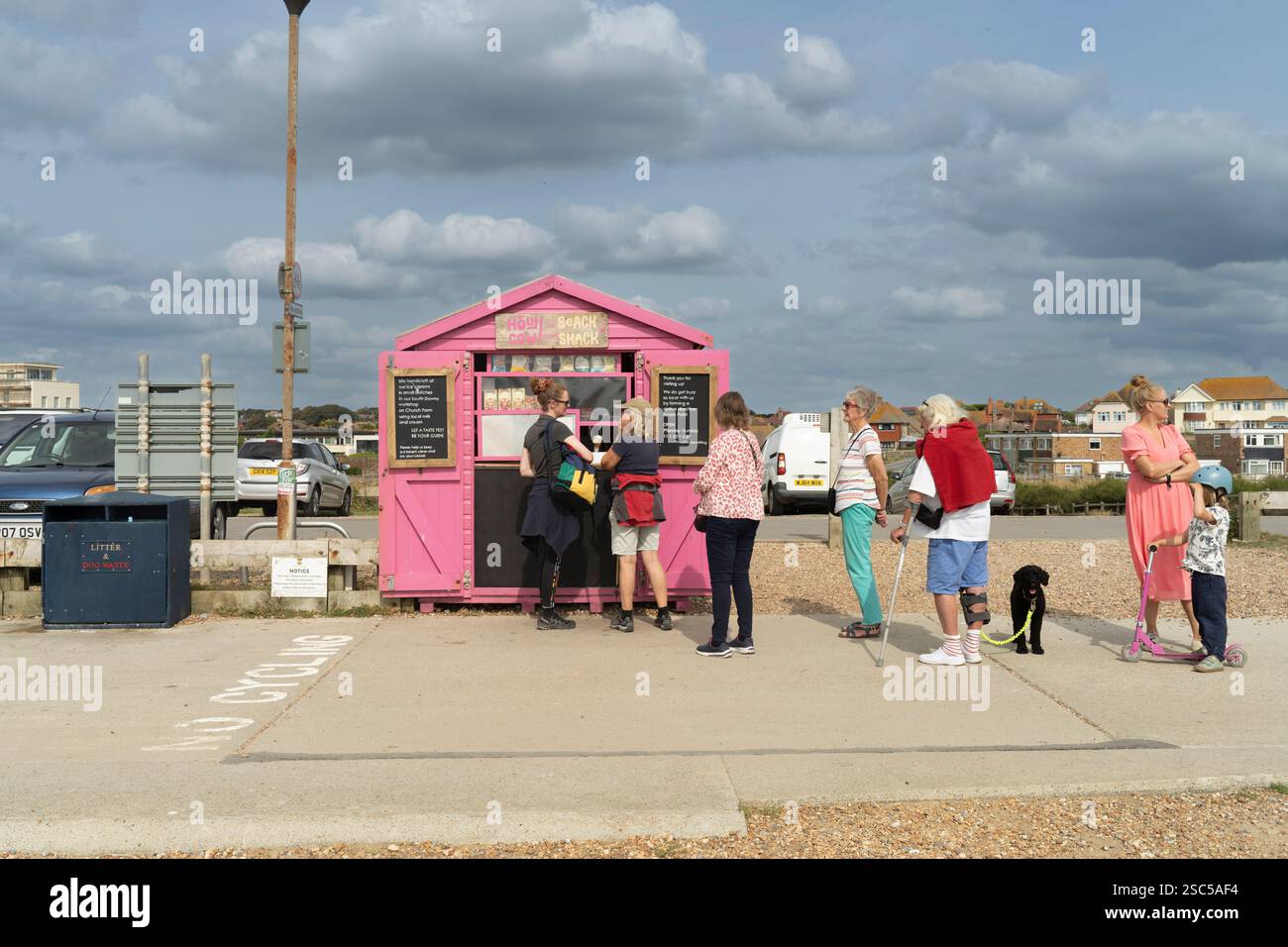 Customers queue at the pink "Holy Beach Cow Shack" food stall on the ...