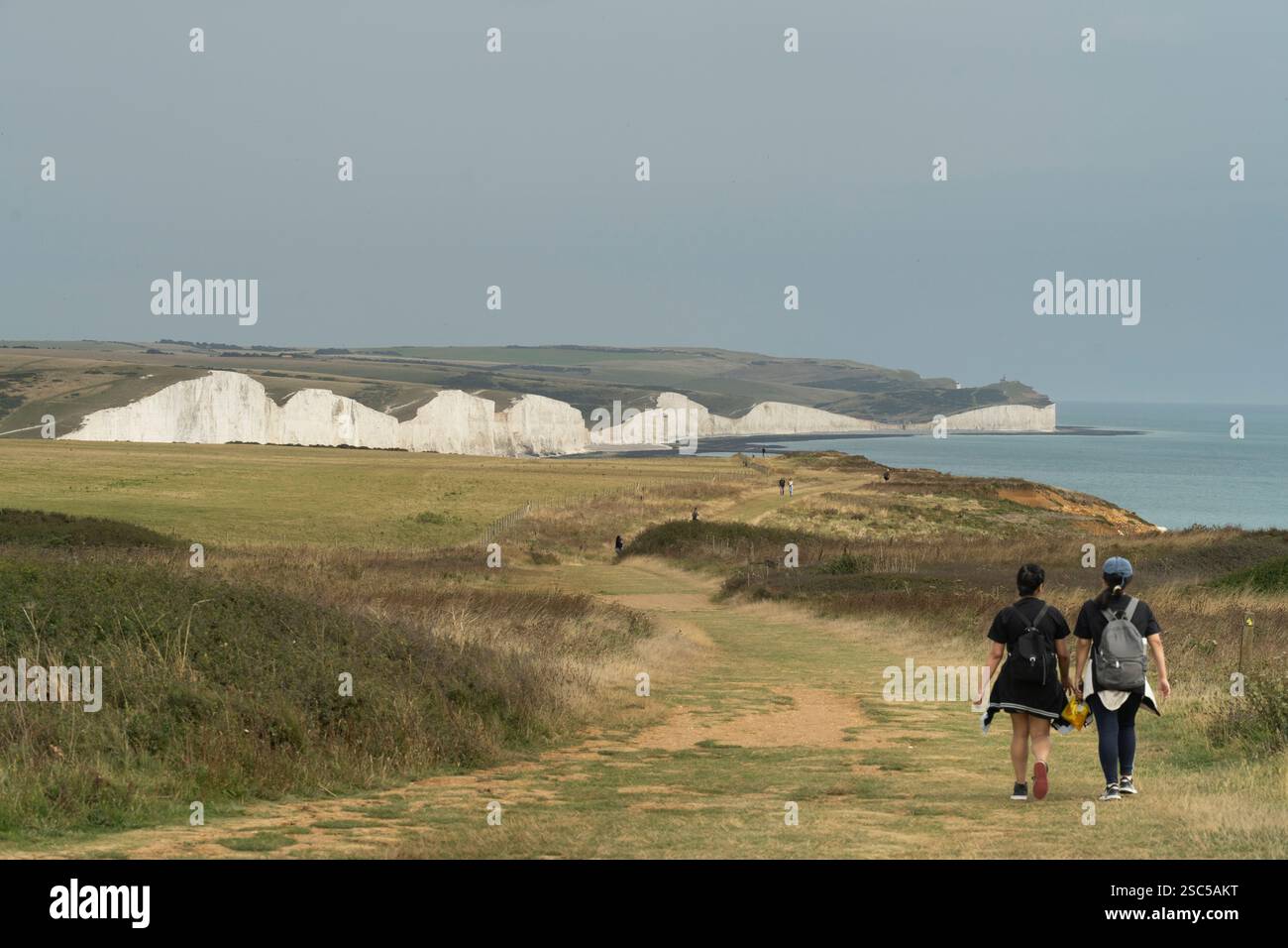 Hikers enjoy the Seven Sisters cliffs, East Sussex, England. Coastal ...