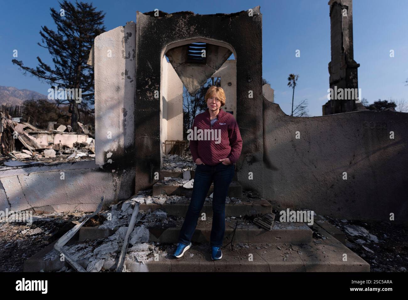 Louise Hamlin stands for a photo in front of her home ravaged by the ...