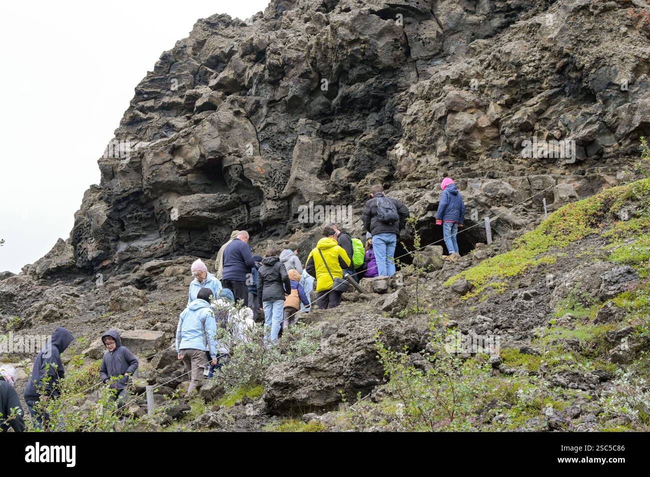 Dimmuborgir, iceland - 24 August 2024: People climbing up to one of the ...