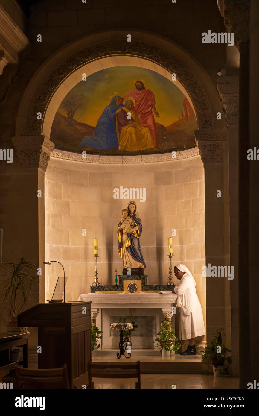 Nazareth, Israel, January 23, 2025: A dark-skinned nun in white attire ...