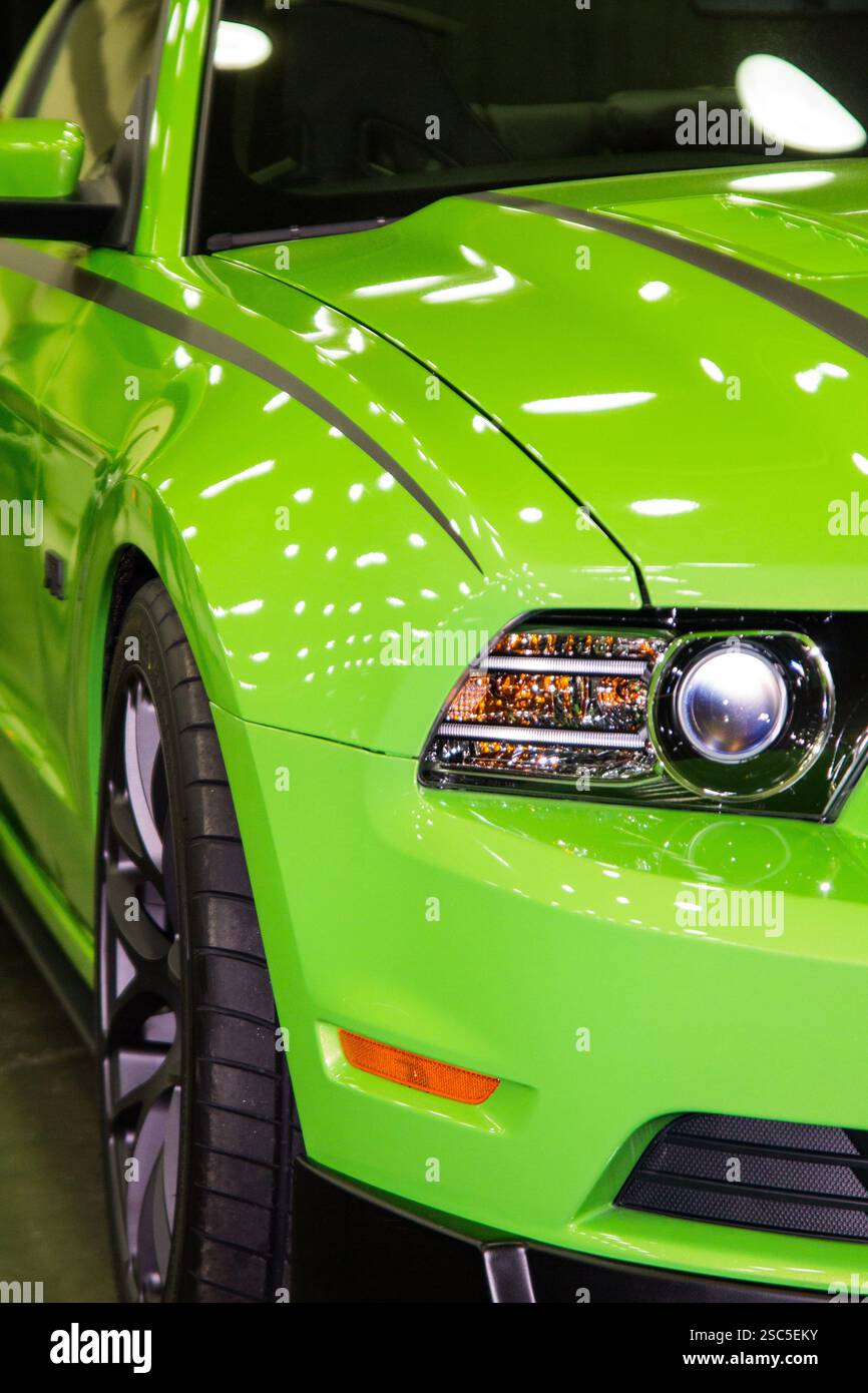 A vibrant lime green Ford Mustang is on display at a car show. The car ...