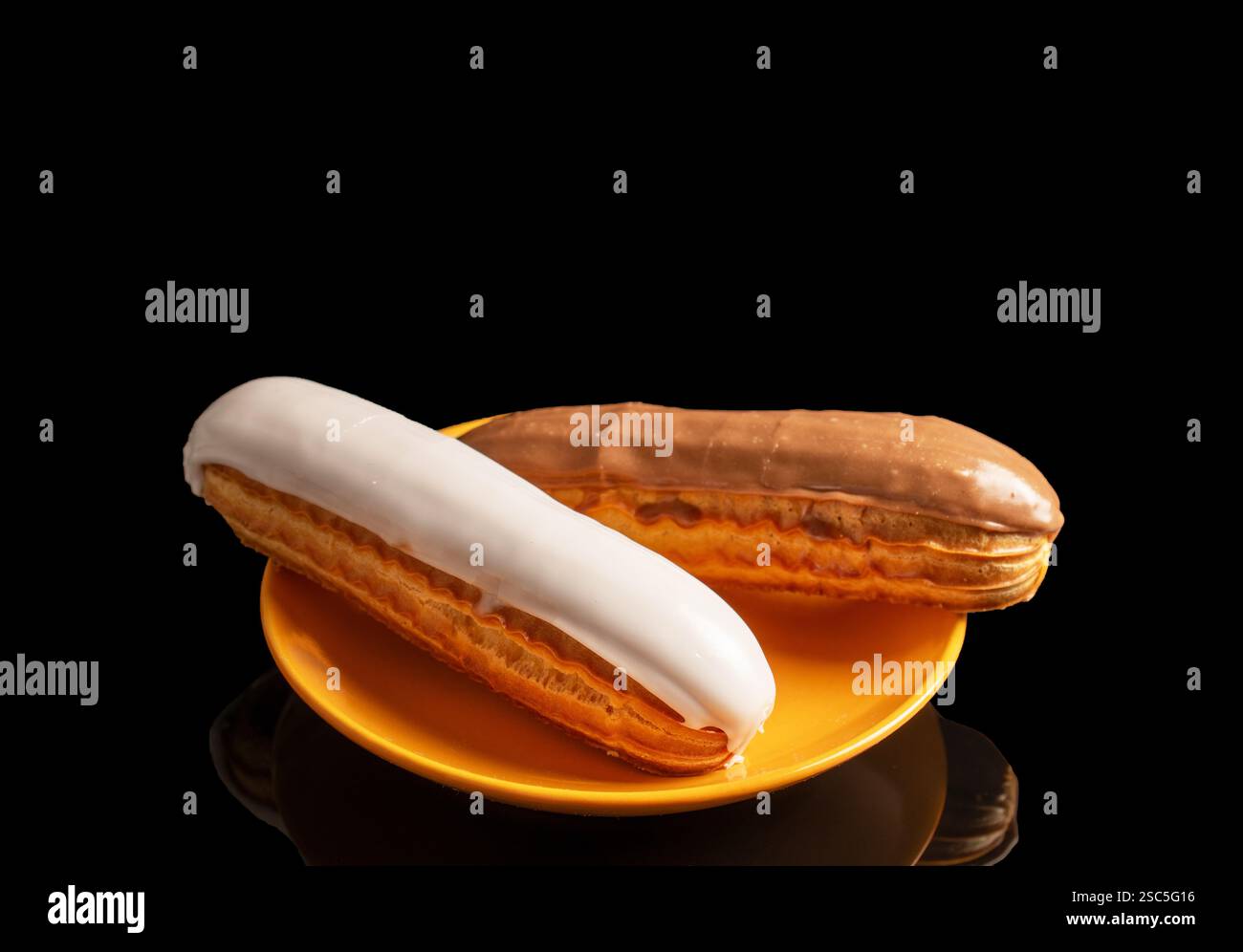 : Two eclairs with cream filling on a ceramic saucer, close-up ...