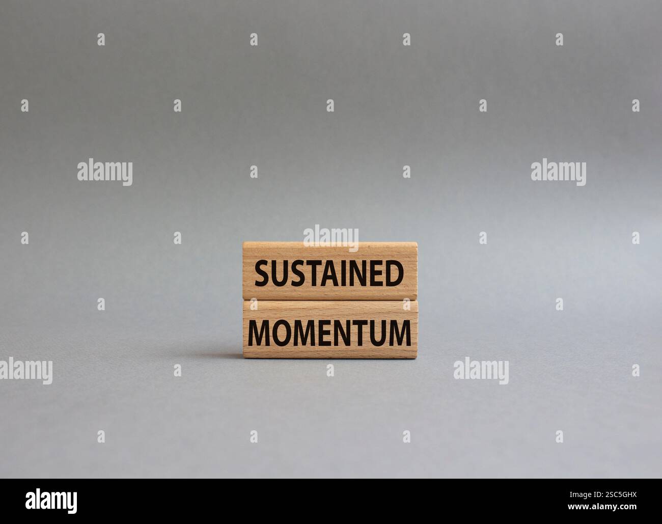 Sustained momentum symbol. Wooden blocks with words Sustained momentum ...