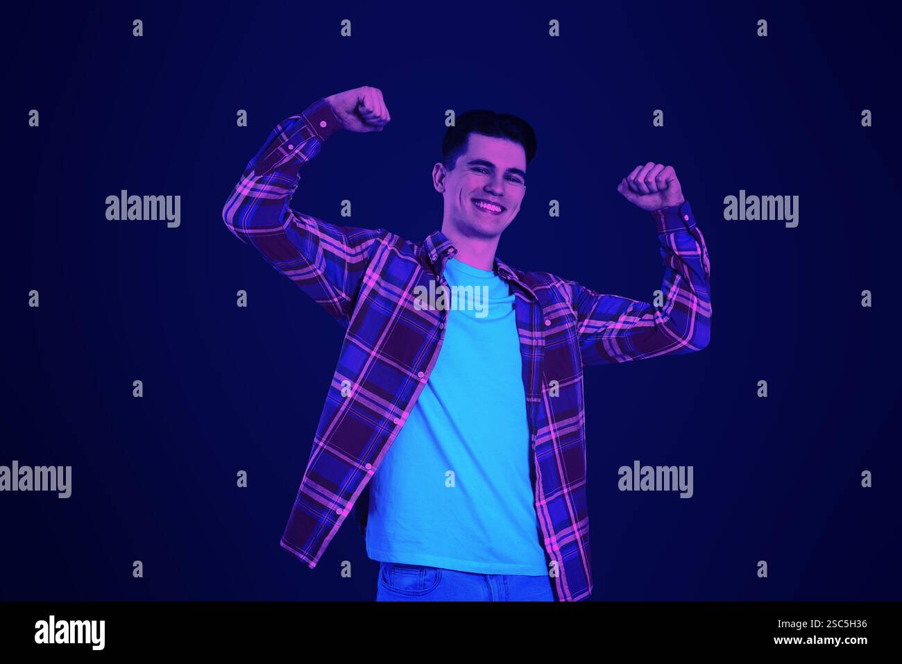 Happy young dancing man in neon light Stock Photo - Alamy