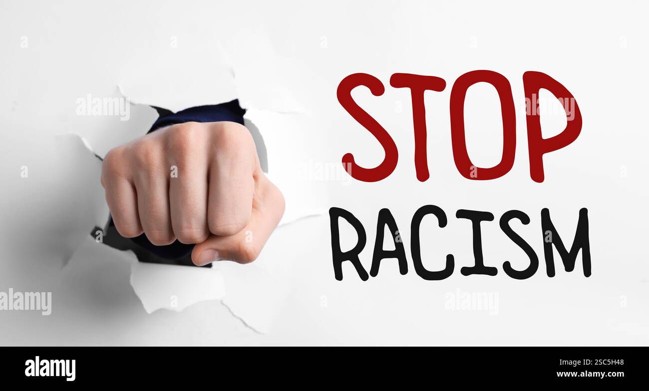 Stop racism. Man breaking through white paper with fist, closeup ...