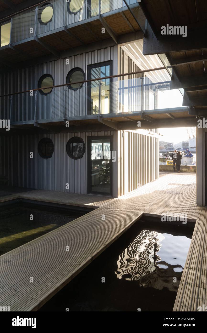 Modern, modular building on the London Canal. Wooden walkways and water ...