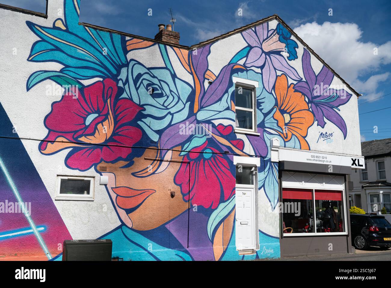 Colorful mural of a woman's face with flowers adorns a building on a street in London. 76a, X ...
