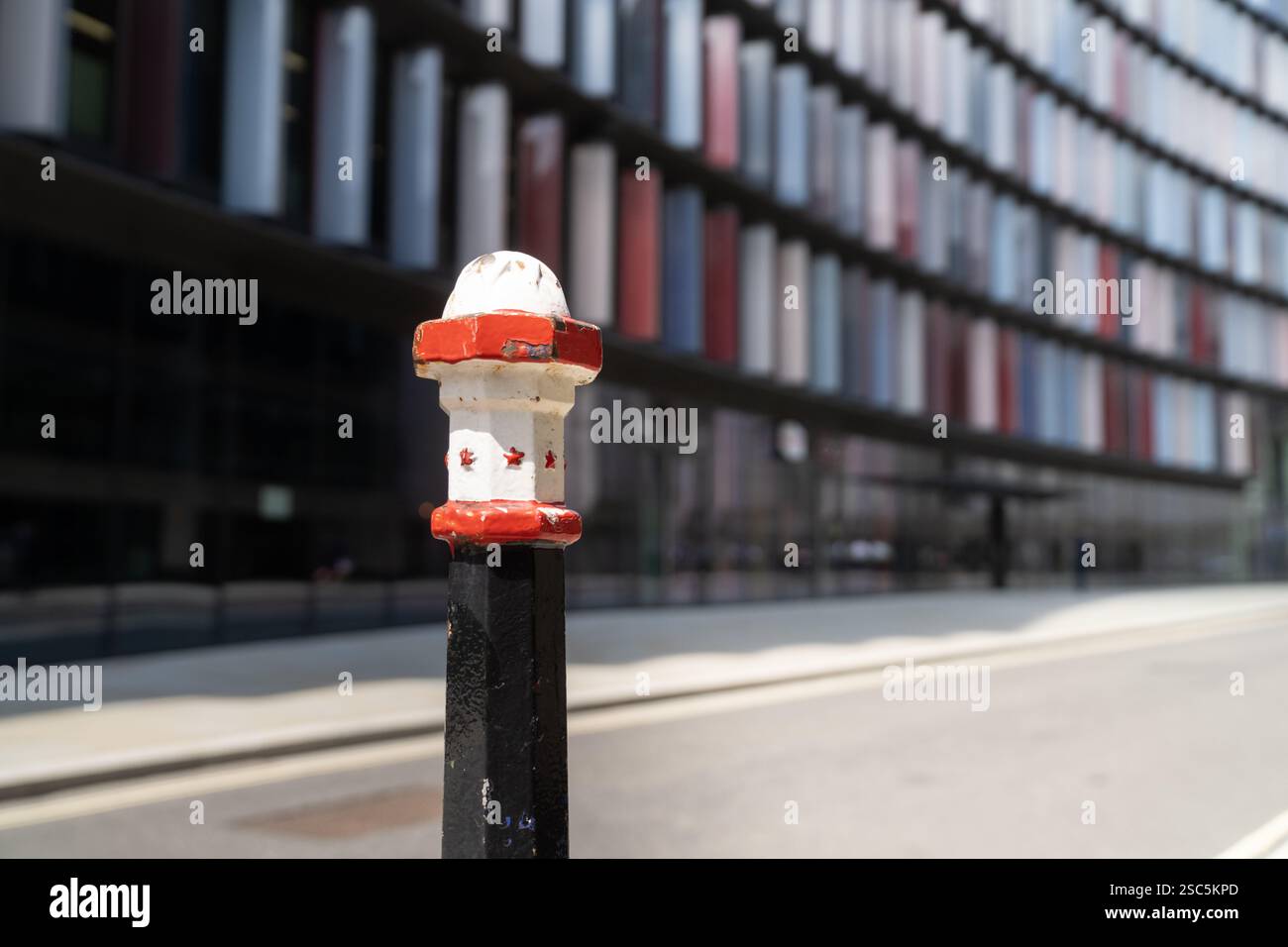 A decorative, red and white bollard stands outside the British Library ...