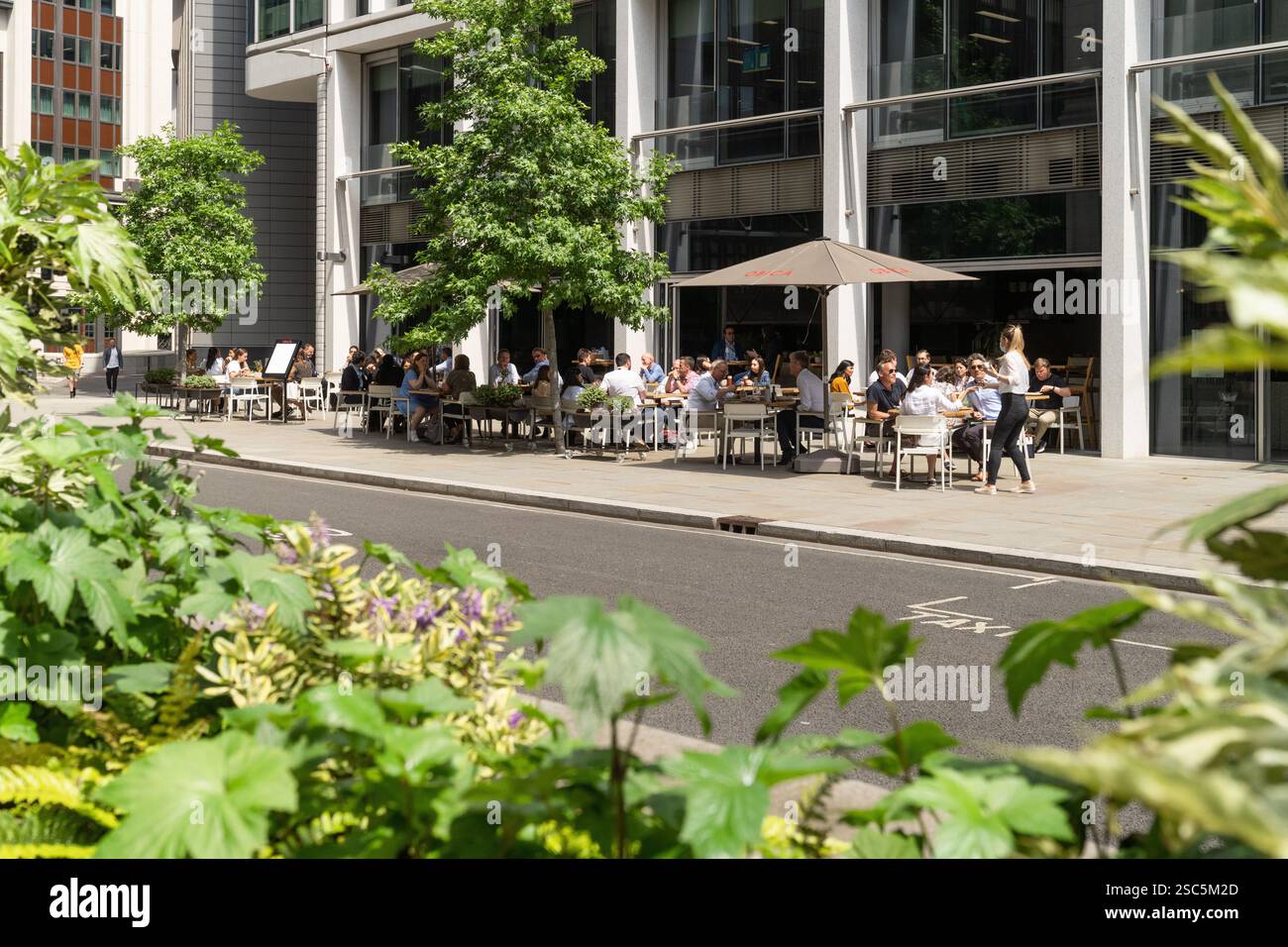People dine outdoors at Obica, a cafe, in the City of London, near the ...
