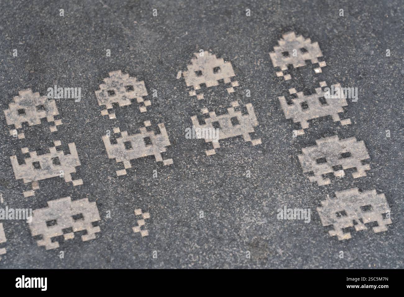 Pixelated Space Invaders, likely stenciled, on the pavement near a ...