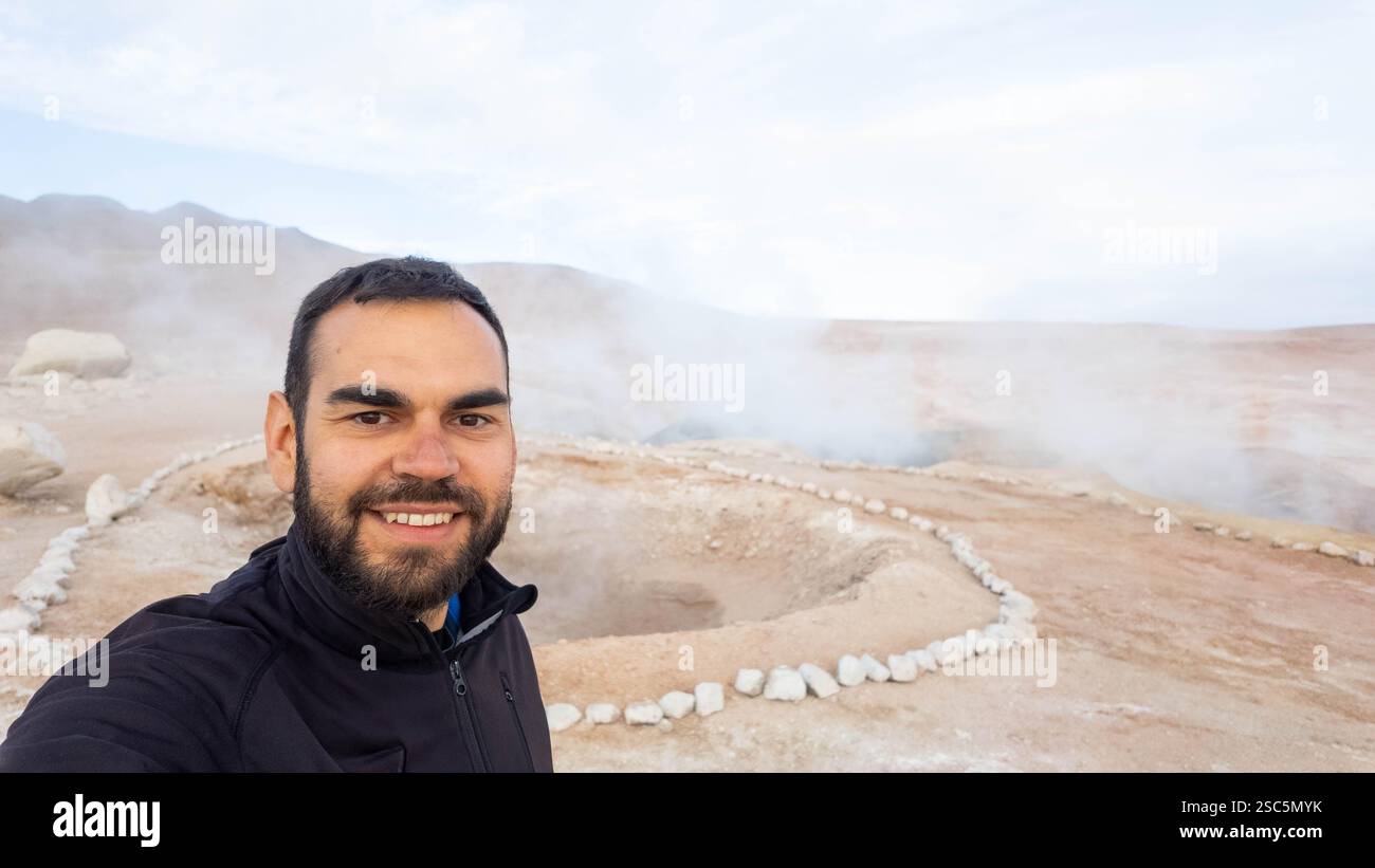 a traveler man taking a selfie by the gas vents of the Uyuni salt flat ...