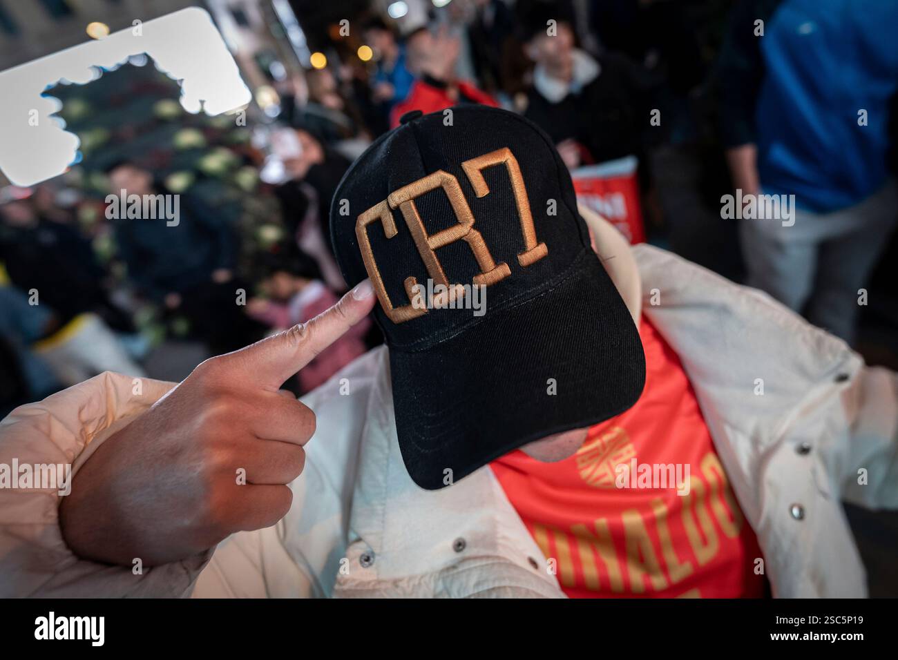 A person shows his CR7 cap during the celebration of soccer player ...