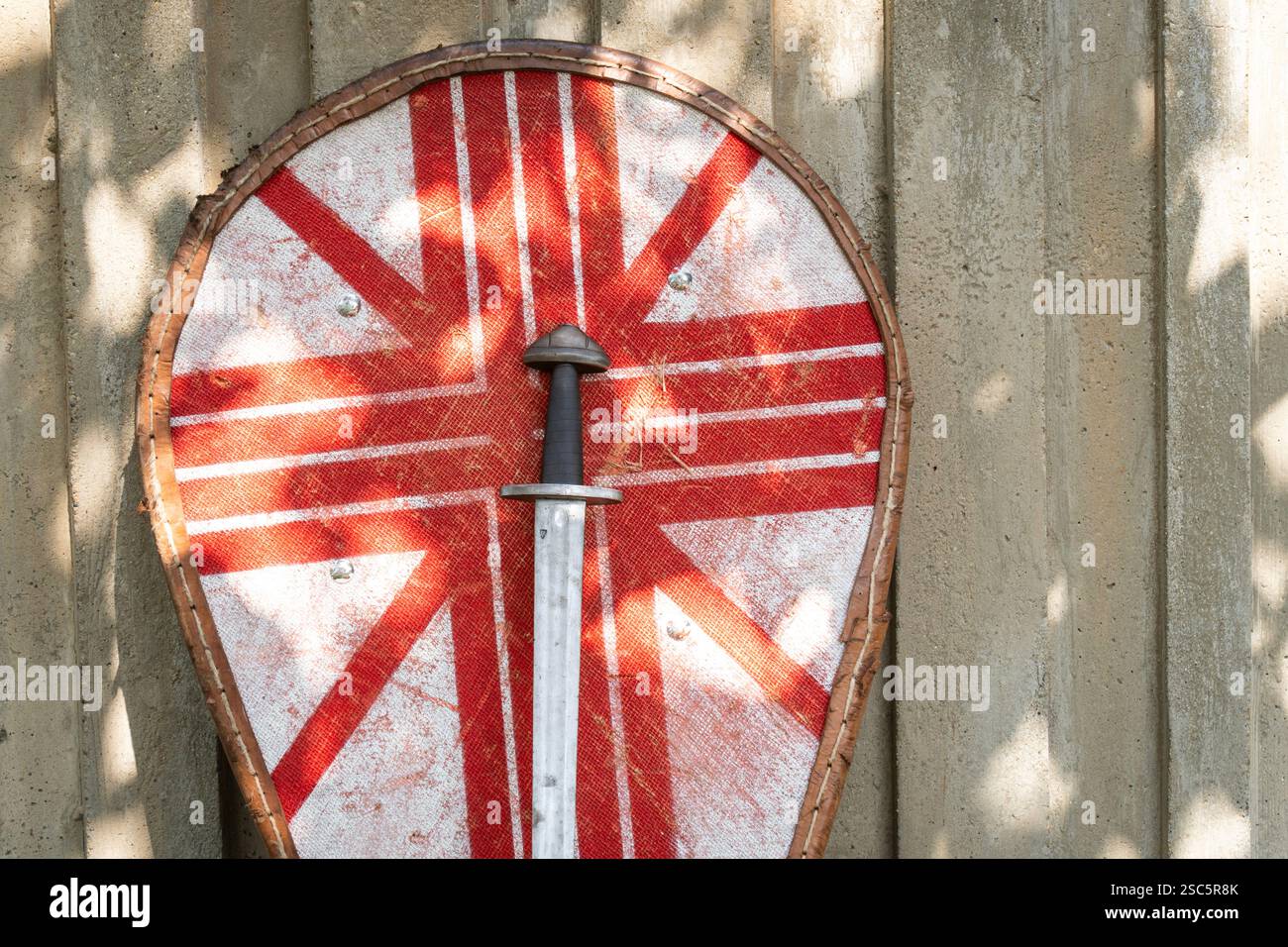 Medieval shield with red patterns and Norman sword in front of rustic ...