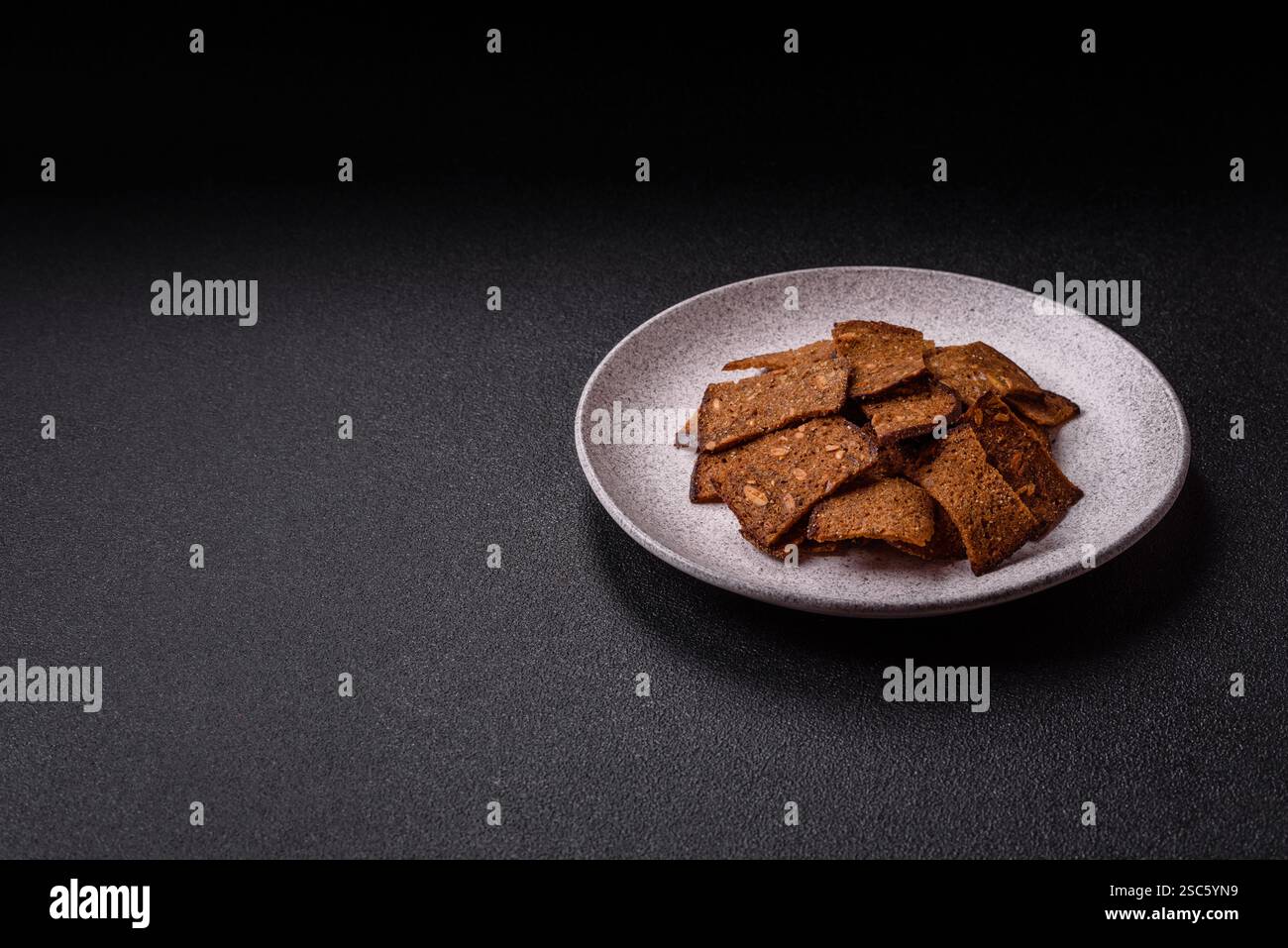 Crispy homemade brown bread chips with seeds and grains, salt, spices ...