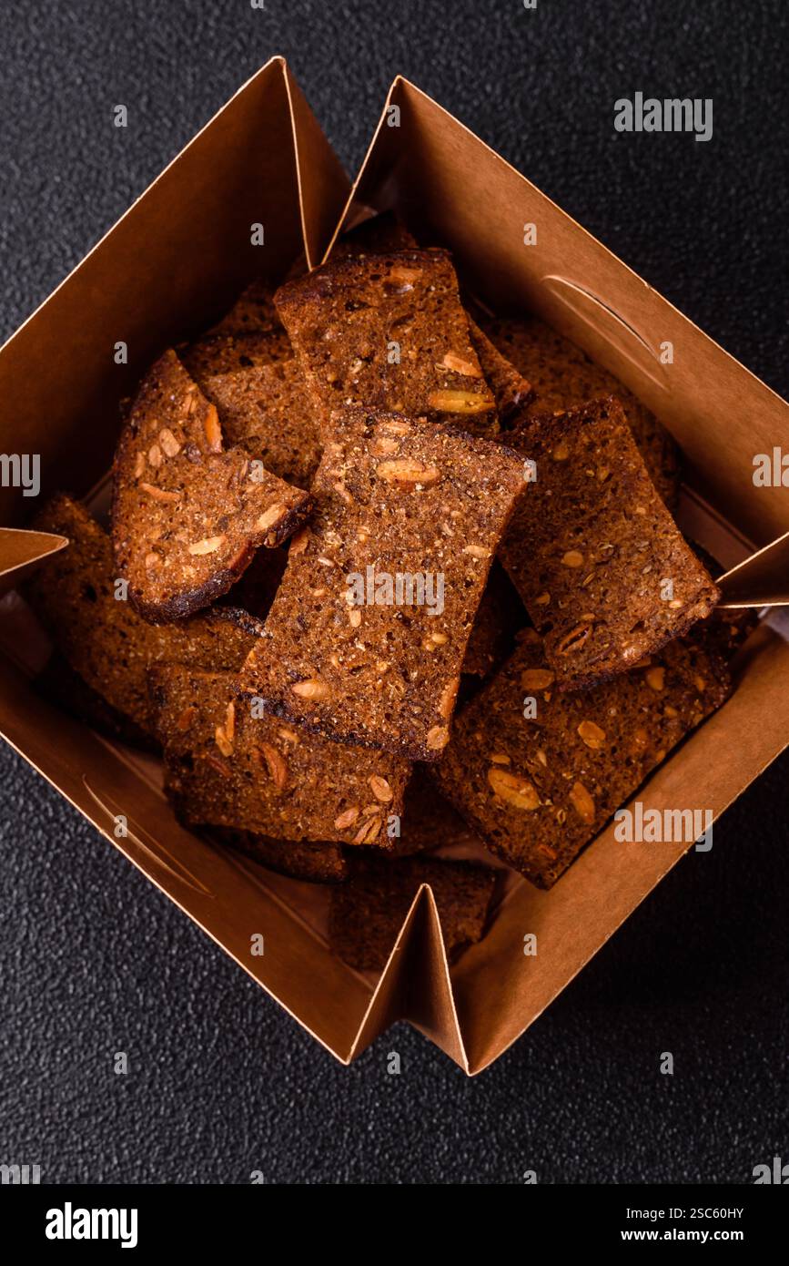 Crispy homemade brown bread chips with seeds and grains, salt, spices ...