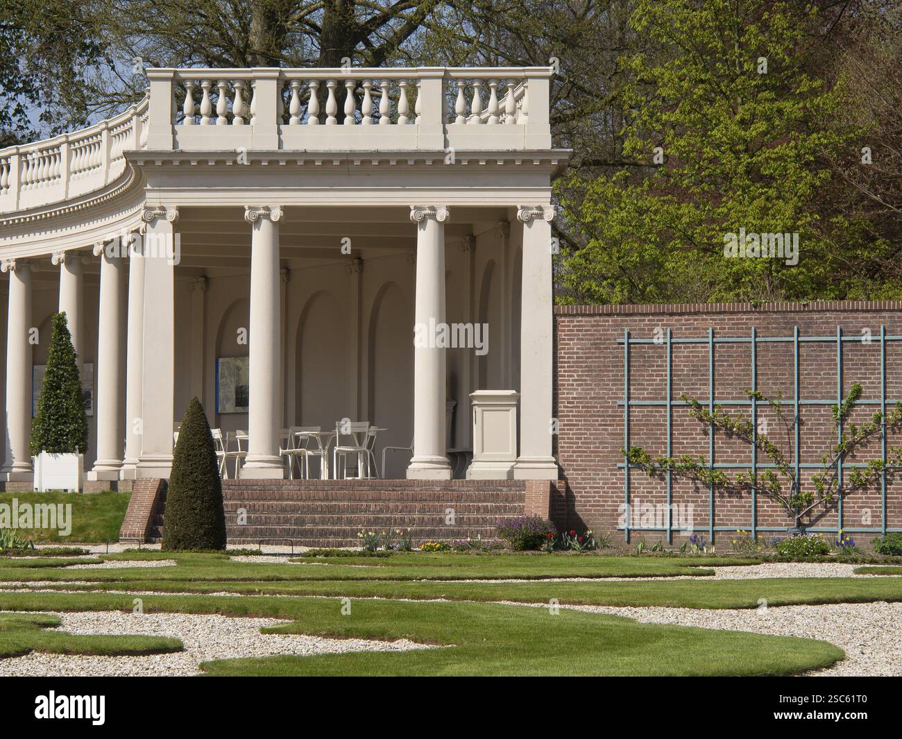 Classic architecture with portico and brick wall in a well-tended ...