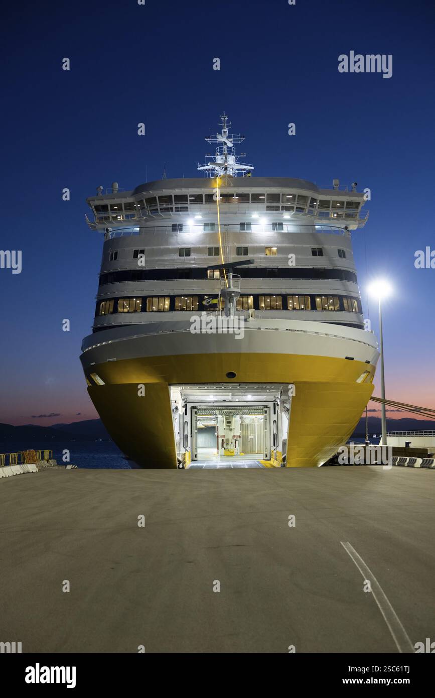 Car ferry with open bow gate hatch anchored in the harbour at sunset ...
