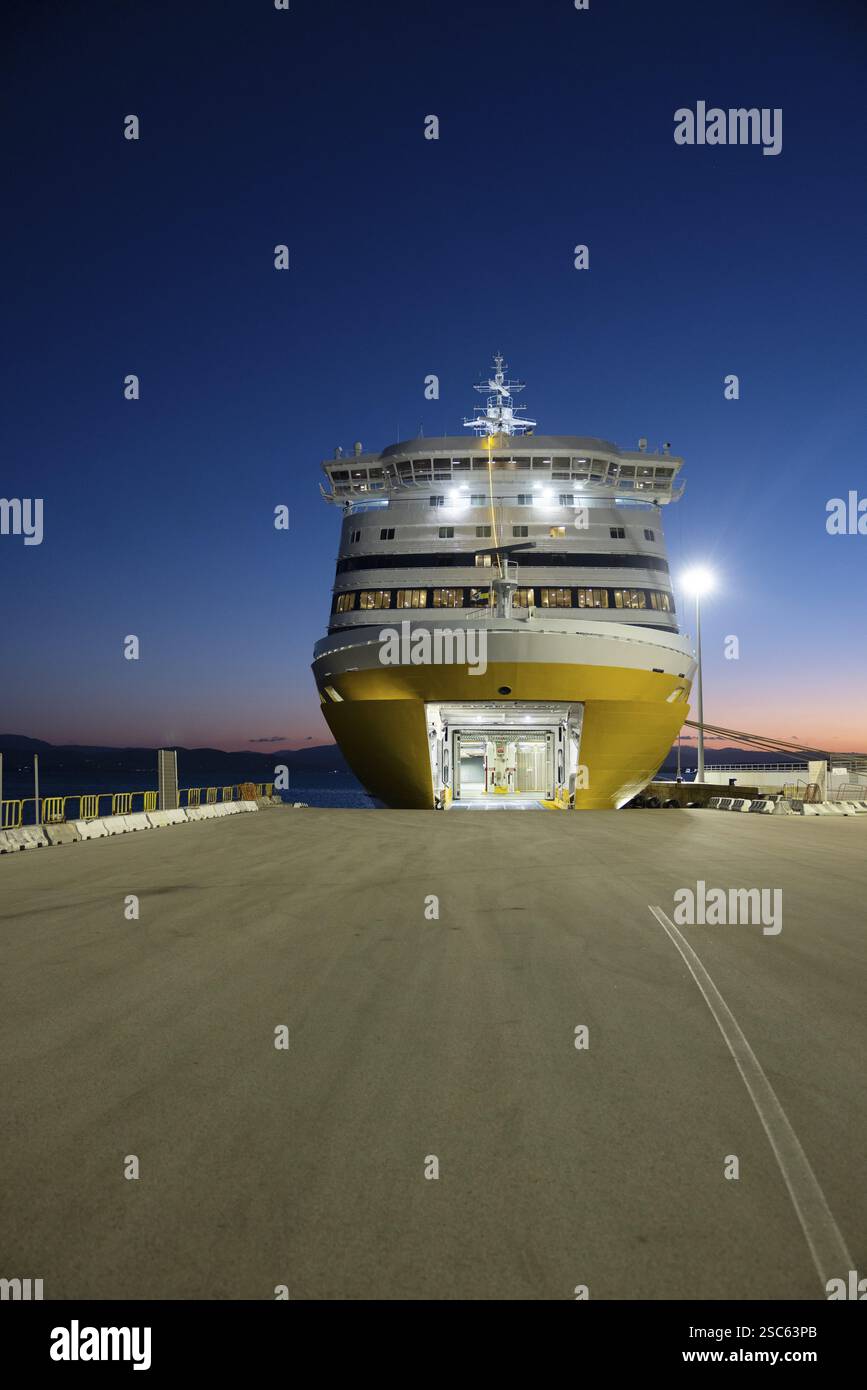 Car ferry with open bow gate hatch anchored in the harbour at sunset ...
