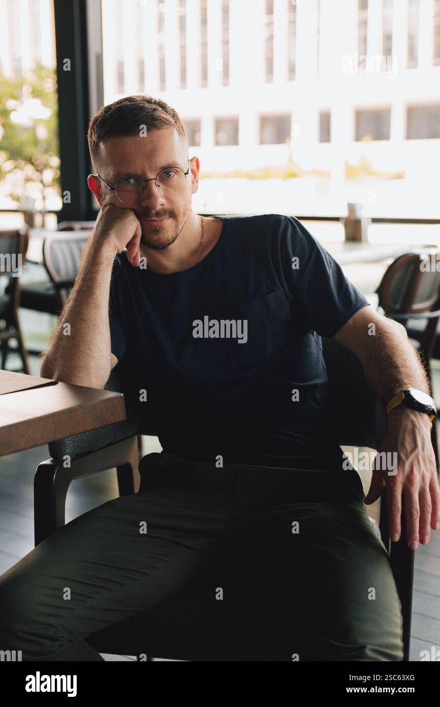 A young guy sits relaxed in a cafe Stock Photo - Alamy