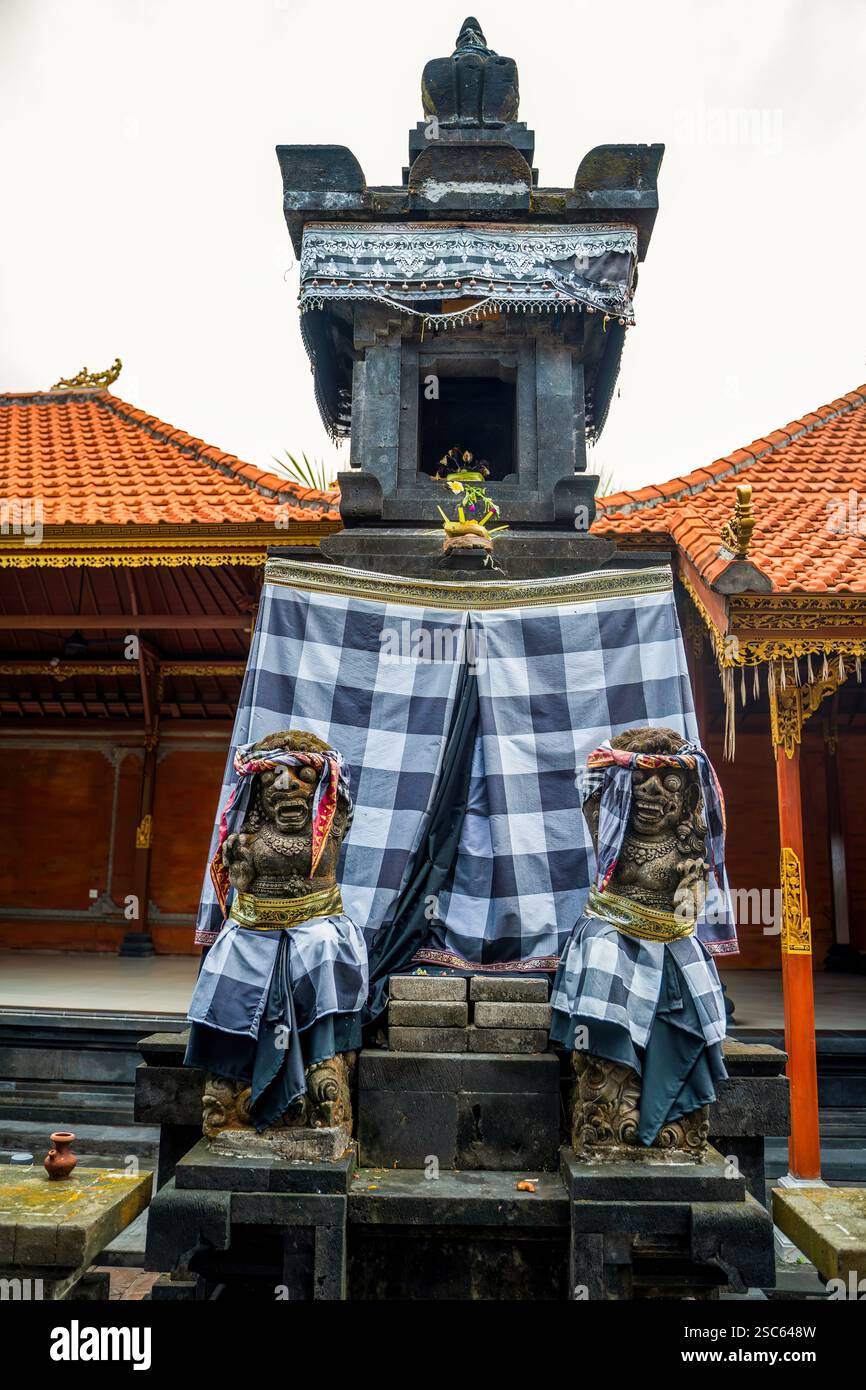 Balinese temple architecture: Guardian figures in checkered cloth flank ...