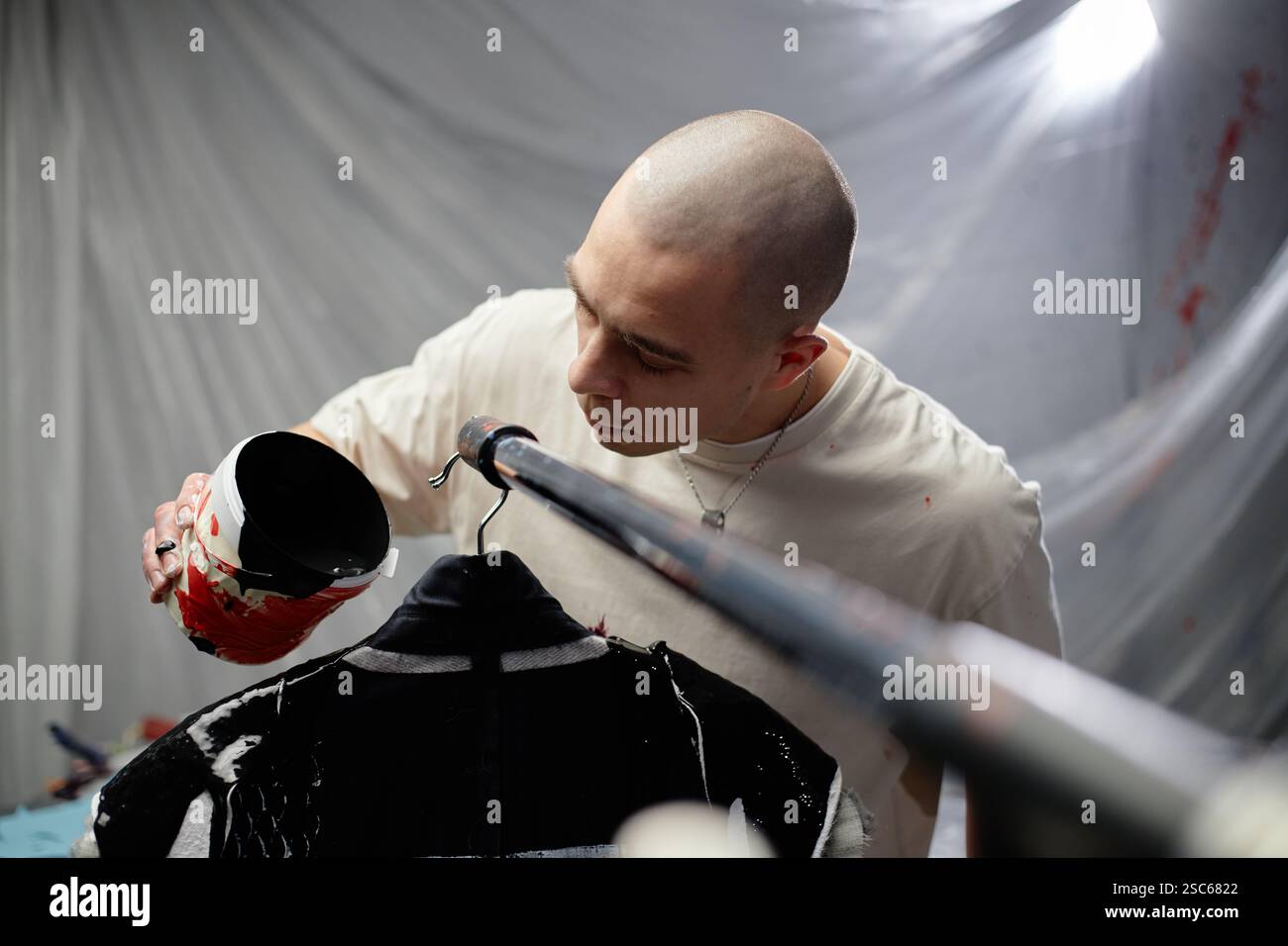 Medium shot of male artist with buzz cut immersed in designing custom ...