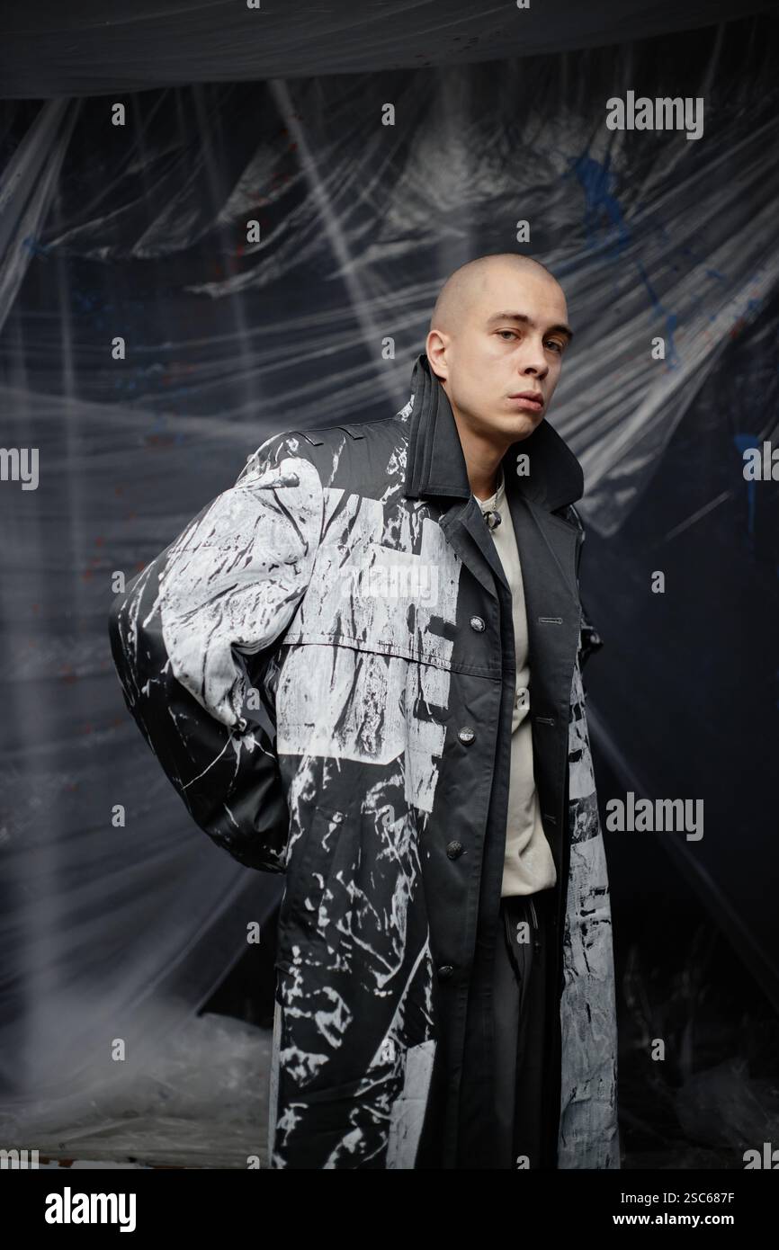 Vertical medium full shot of male fashion artist with buzz cut wearing ...