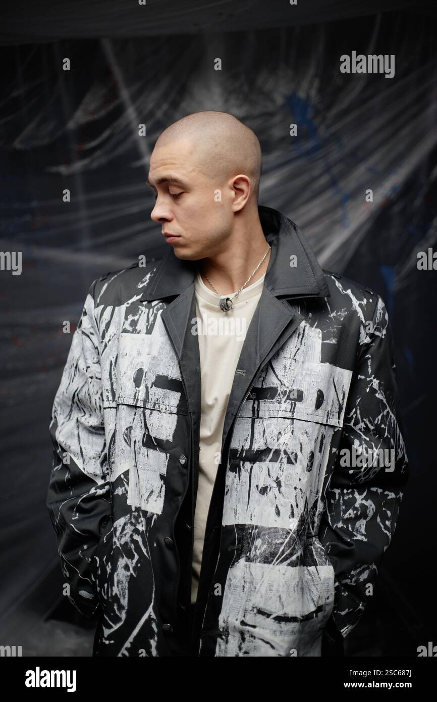 Vertical portrait of male fashion artist with buzz cut wearing custom ...