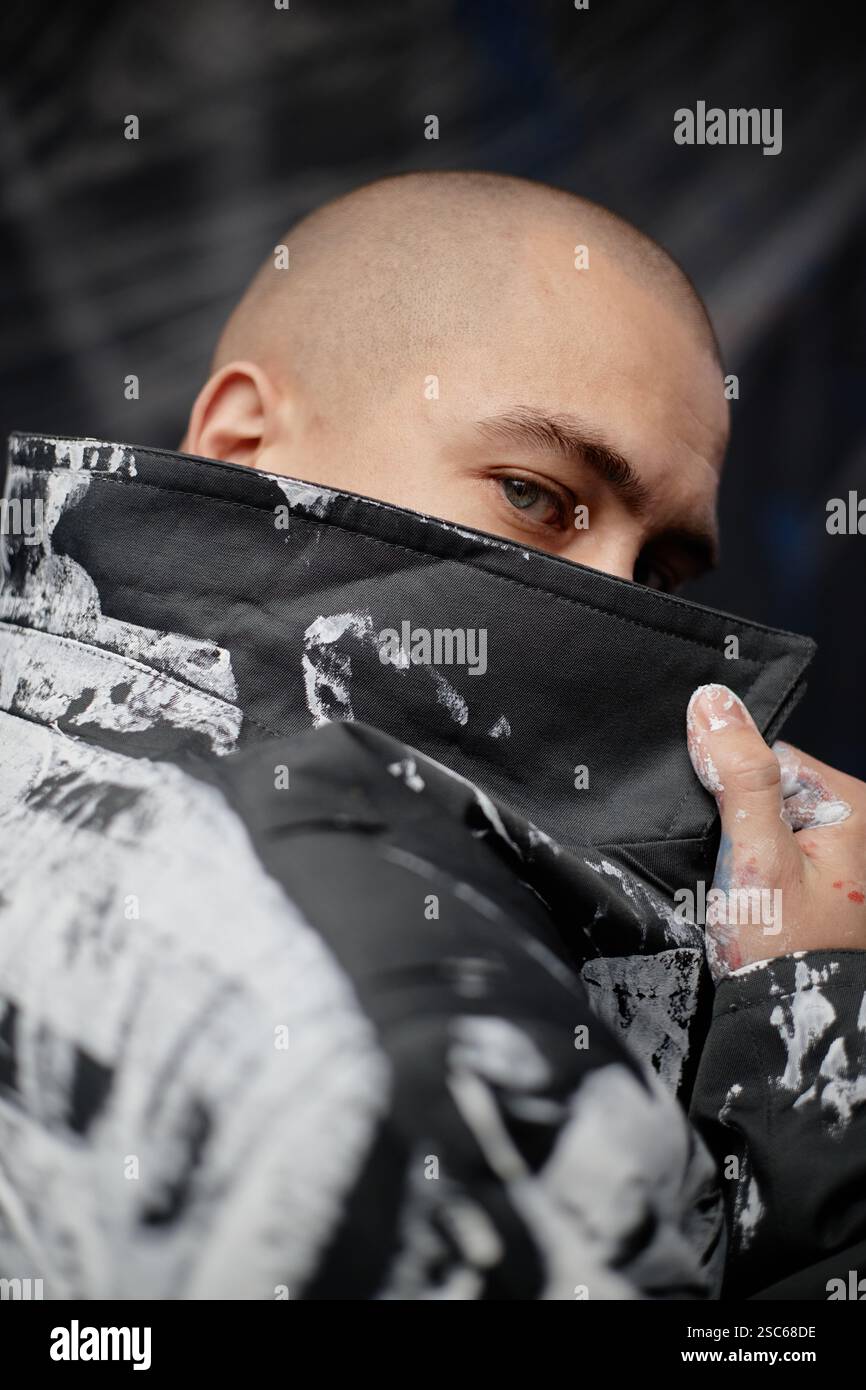 Vertical portrait of male fashion designer with buzz cut looking at ...