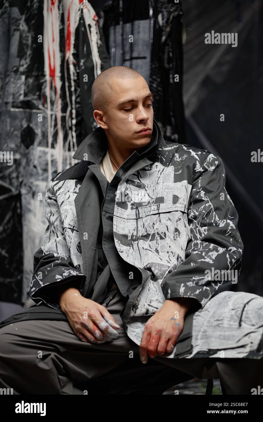 Medium full shot of male fashion artist with buzz cut wearing painted ...