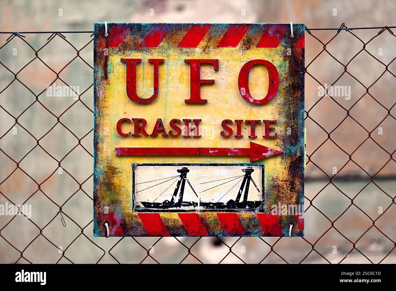 Vintage UFO crash site squared metal sign on a metal fence in ...