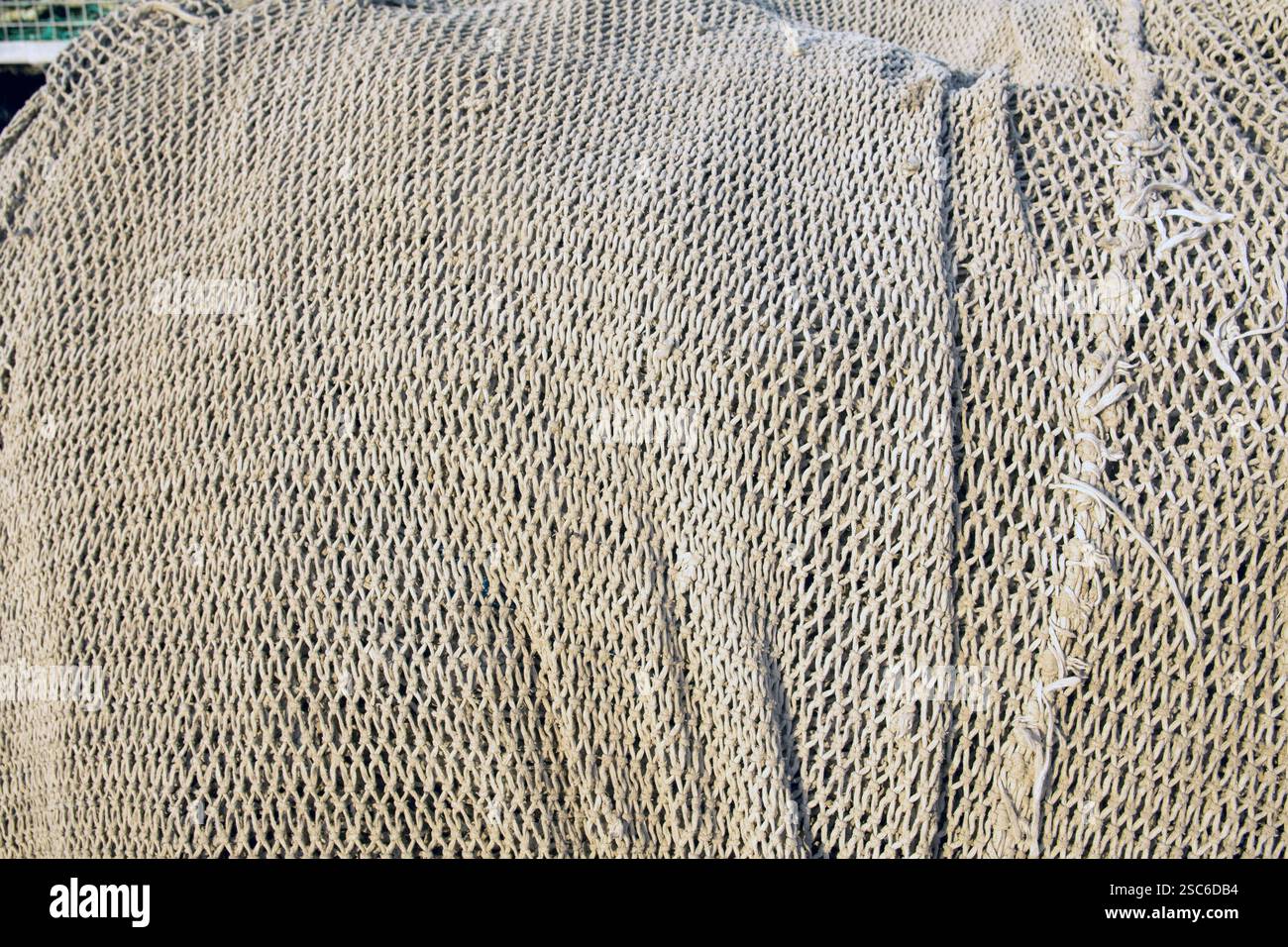 Close-up of beige fishing nets with visible knots and patterns ...
