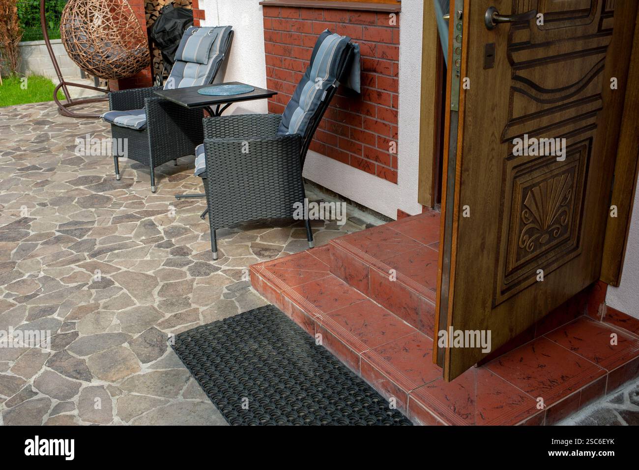 Half opened door into the beautiful summer terrace and blooming garden ...