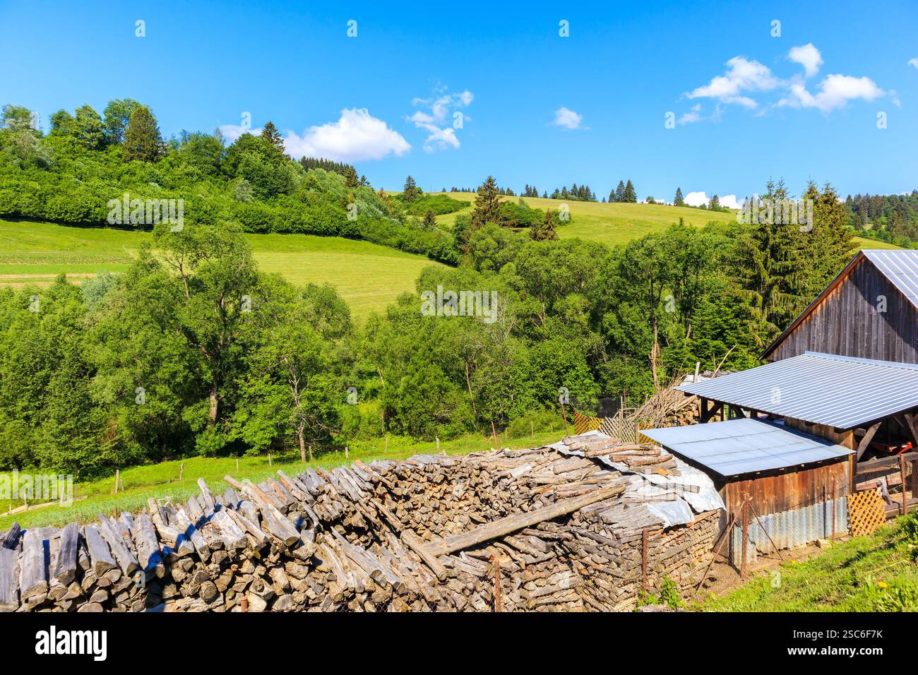 Stack of fire wood and view of Pribis village with houses, Orava ...