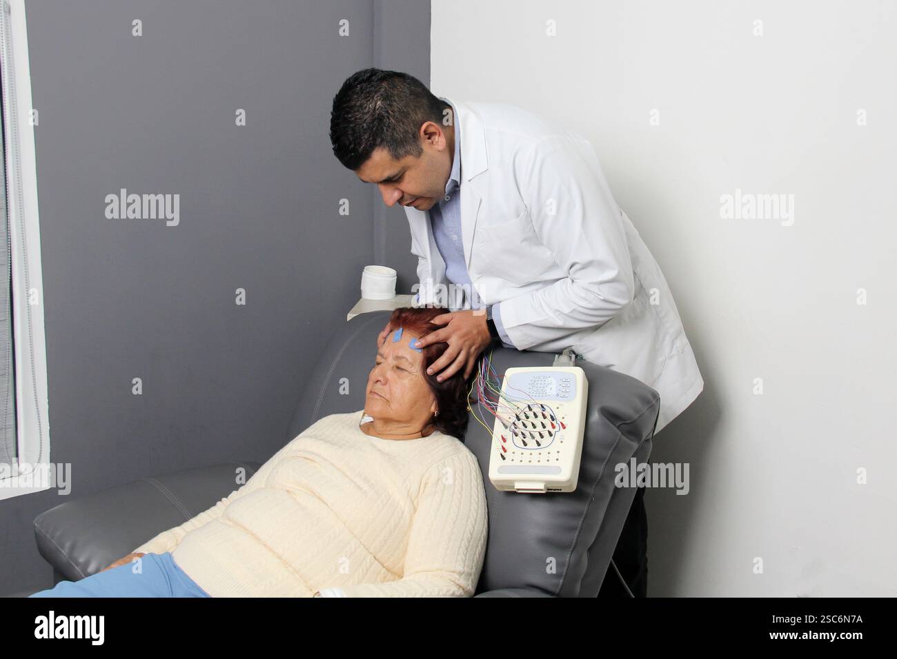 Elderly Latin woman undergoes EEG electroencephalogram to detect dementia or Alzheimer's disease ...