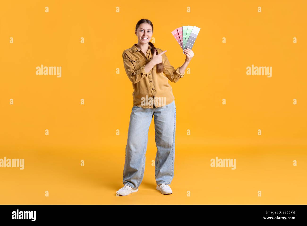 Woman with paint color selection chart on orange background Stock Photo ...