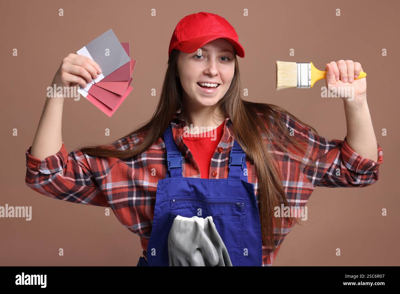 Professional painter with brush and color samples on brown background ...