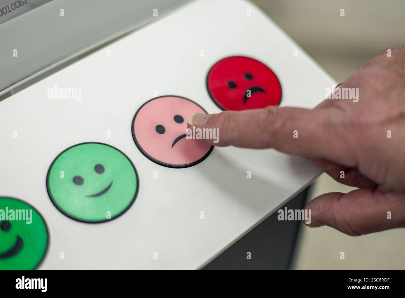 Hand pressing a slightly dissatisfied emoji button on a customer ...