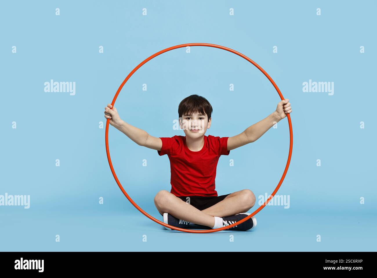 Boy with hula hoop on light blue background Stock Photo - Alamy