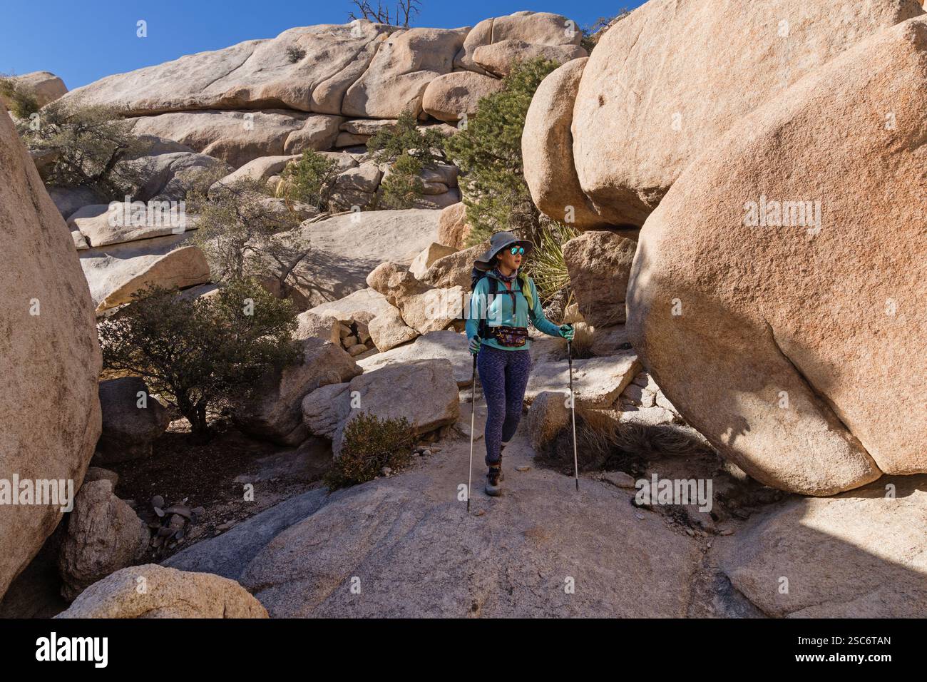 Asian woman hiking into the Wonderland of Rocks in Joshua Tree National ...
