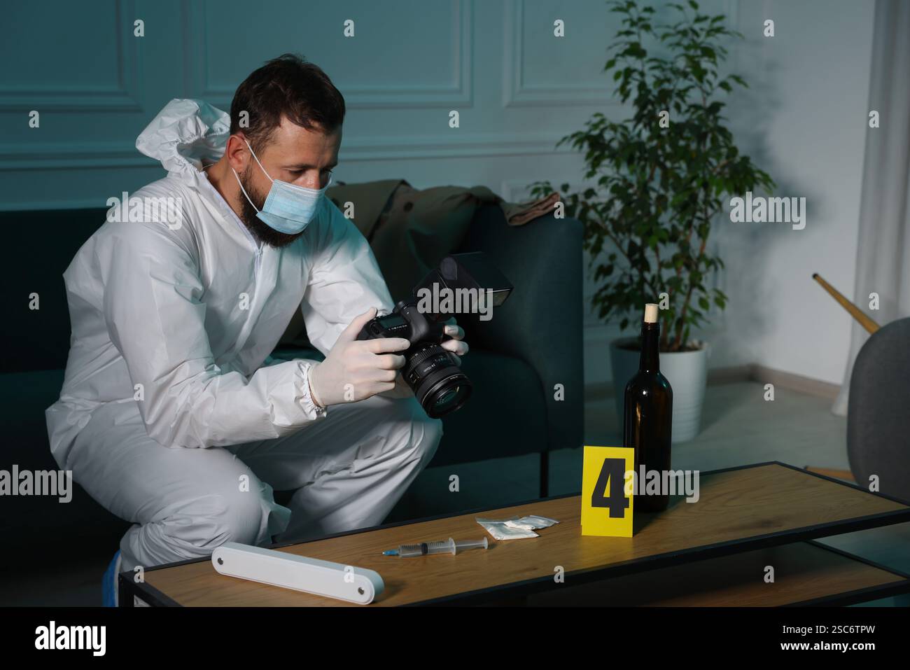 Forensic expert with camera taking photo of evidences at crime scene ...