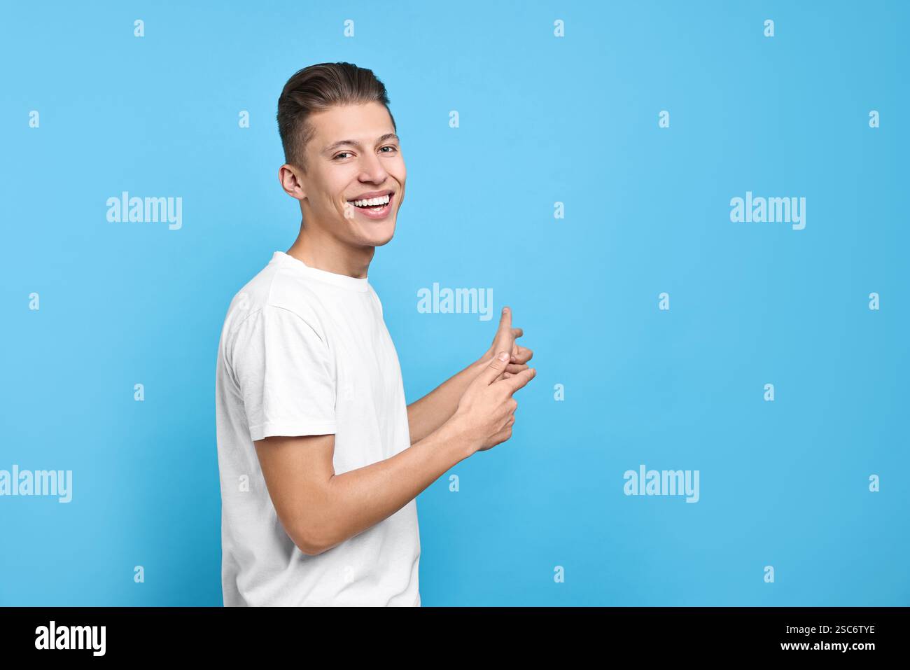 Happy man welcoming friends or guests on light blue background. Space ...