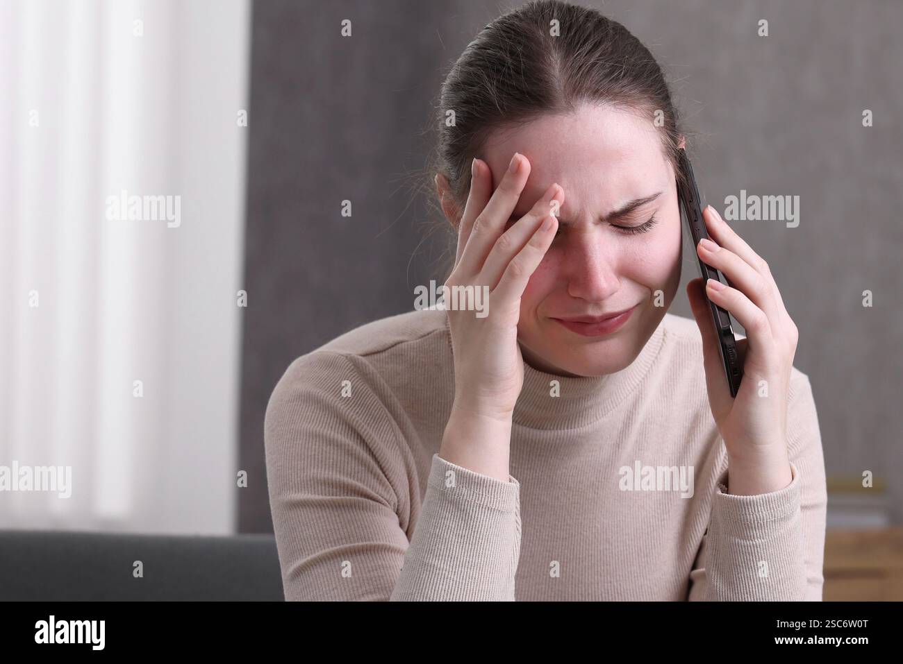 Stressed woman calling hotline for mental health help at home Stock ...