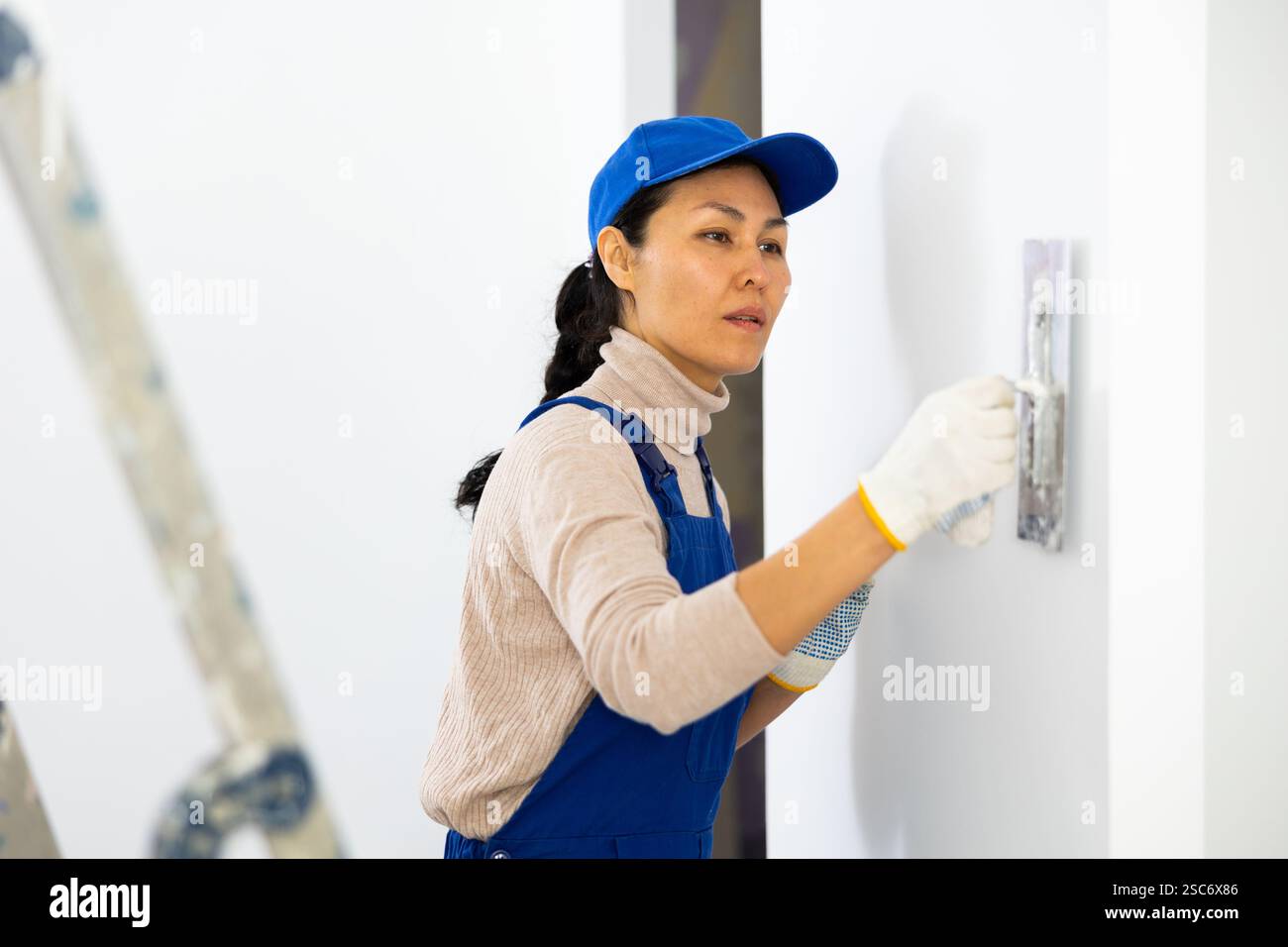 Woman applying plaster to a wall with floated trowel Stock Photo - Alamy