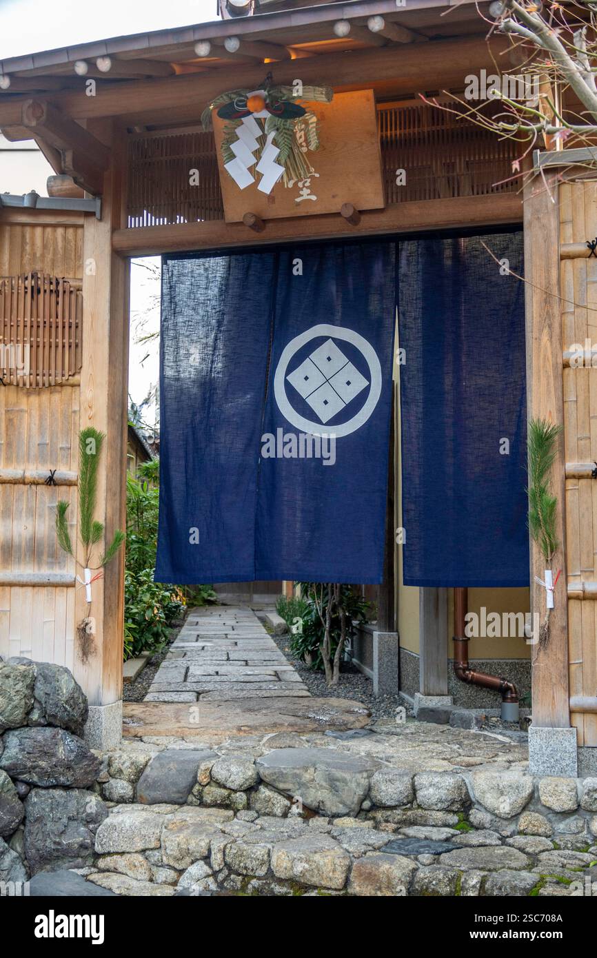 traditional Japanese entrance with blue fabric curtain and stone ...